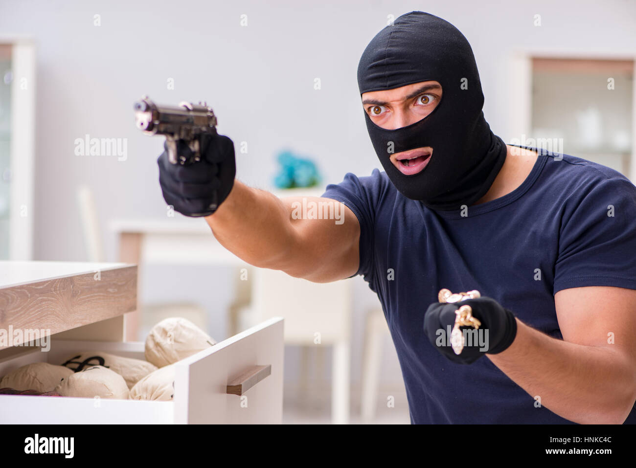 Robber wearing balaclava stealing valuable things Stock Photo - Alamy