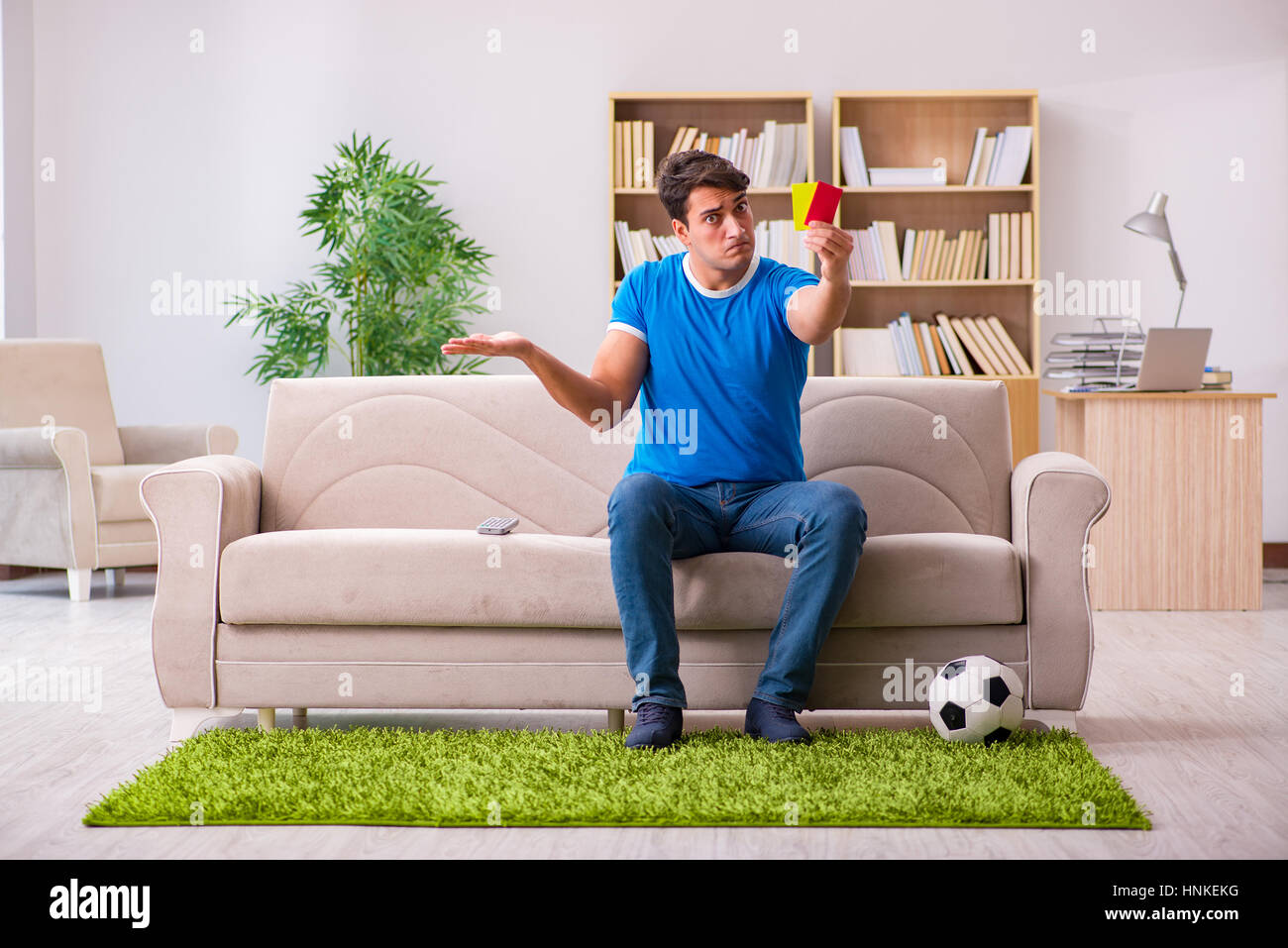 Man watching football at home sitting in couch Stock Photo - Alamy