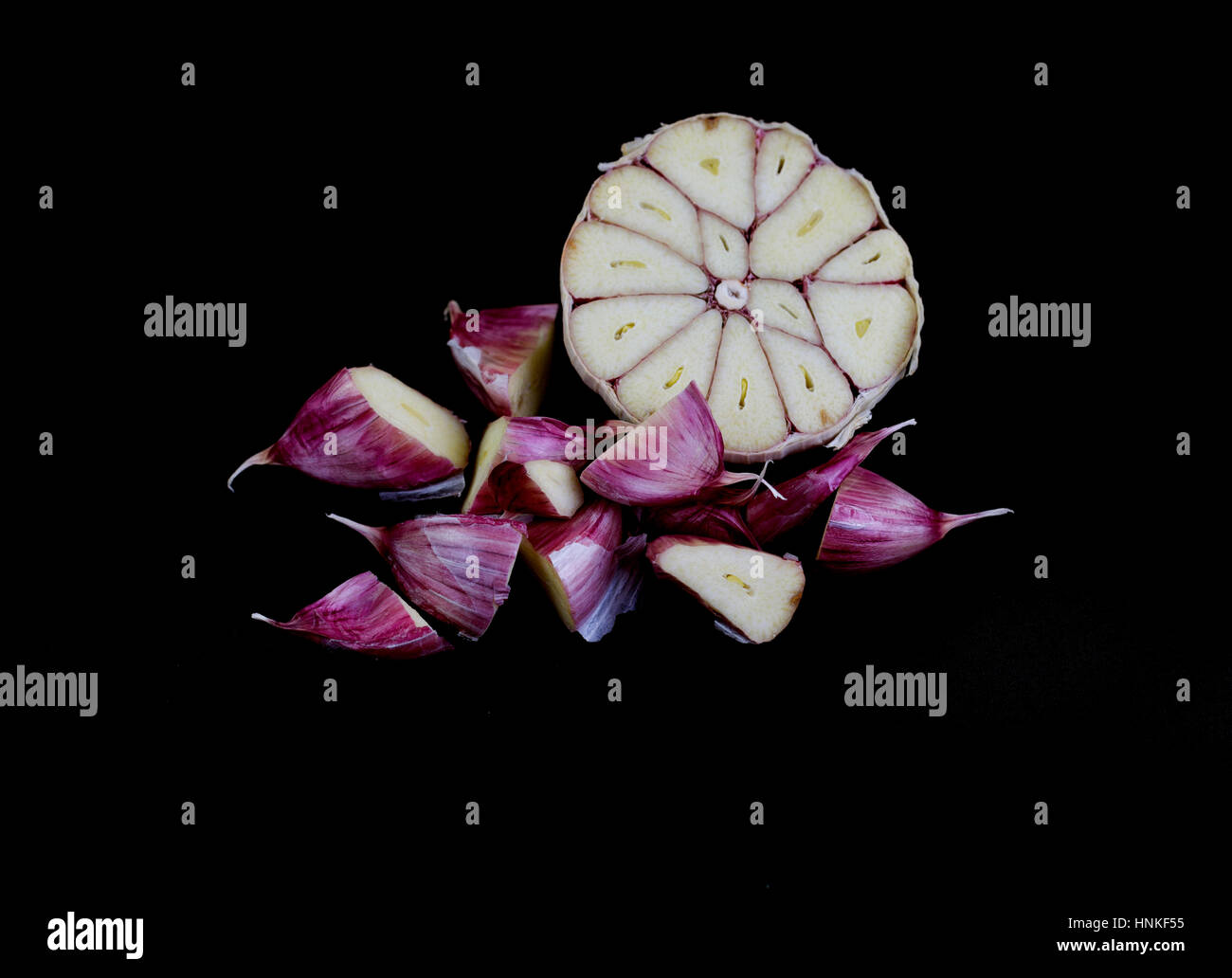 Cloves of garlic, Allium sativum, cut on the cross section, on black ...