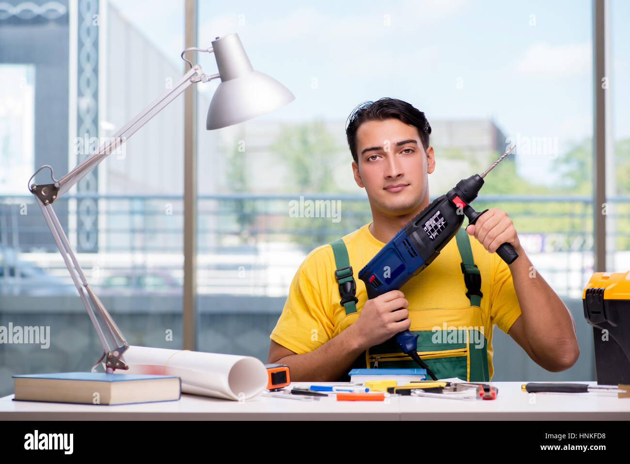 Construction worker sitting at the desk Stock Photo - Alamy