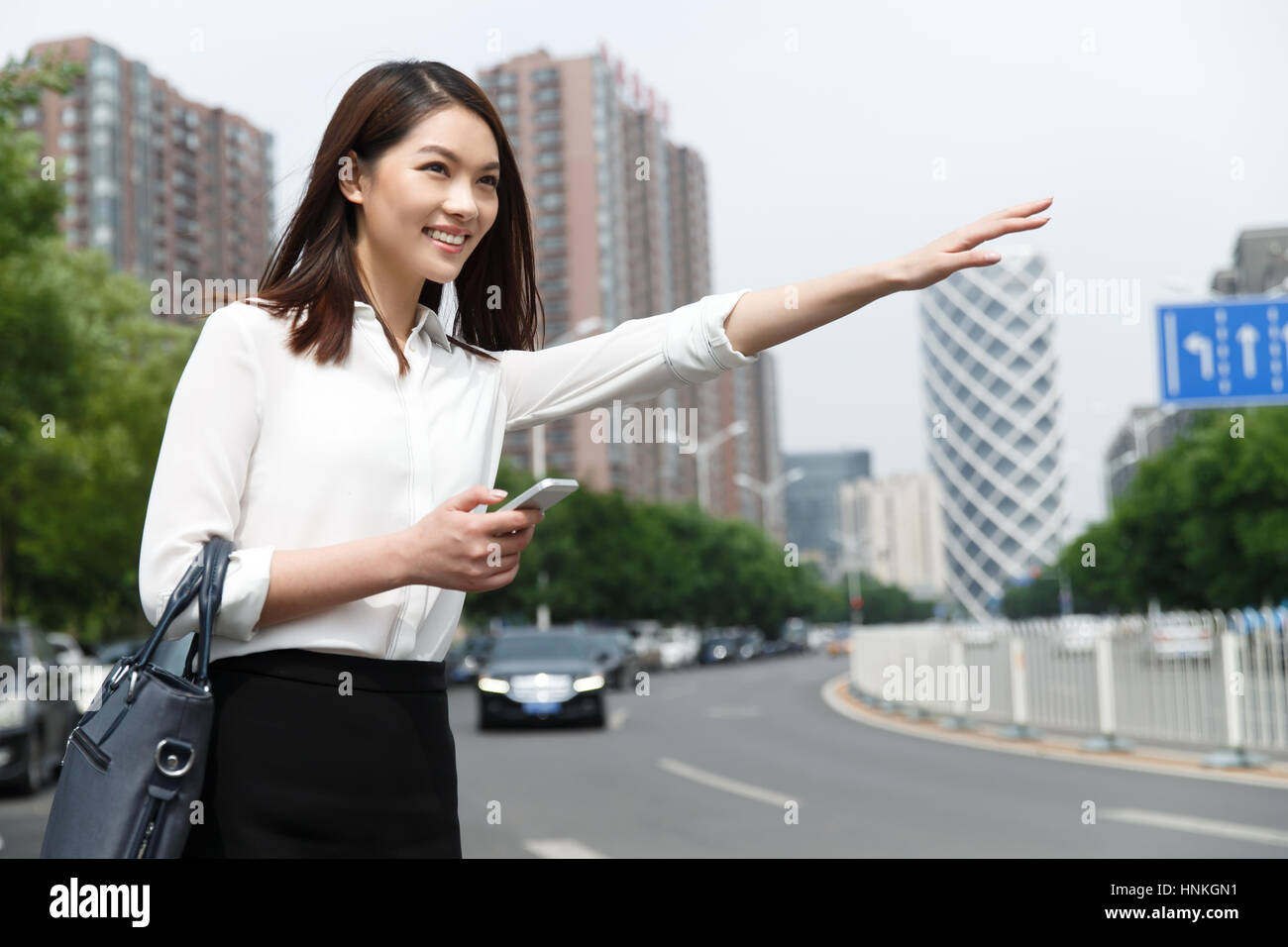 Young woman waiting for a taxi on the road Stock Photo - Alamy