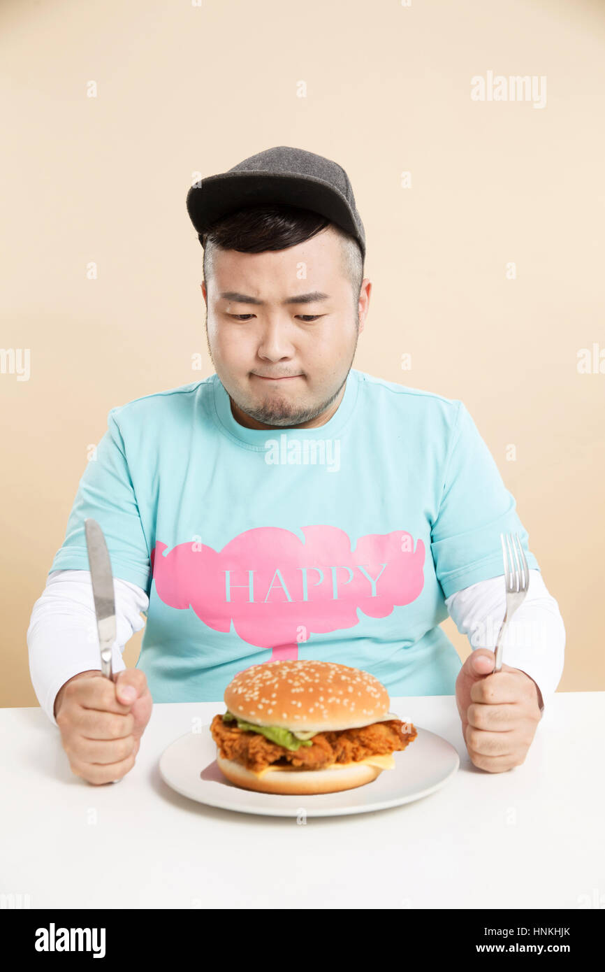 Little fat man eating hamburgers Stock Photo - Alamy
