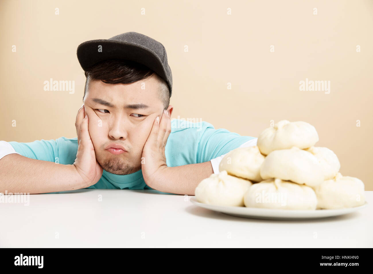 Little fat man to eat steamed stuffed bun Stock Photo - Alamy