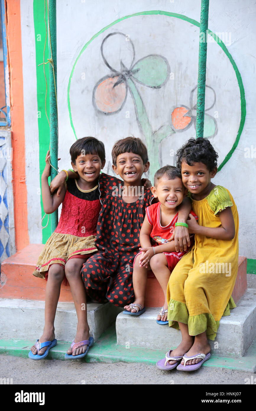 Children in Tangra Slum in Calcutta sit in front of a wall painted with ...