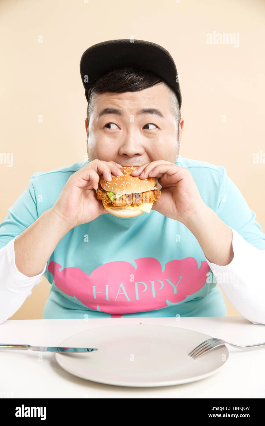 Little fat man eating hamburgers Stock Photo - Alamy