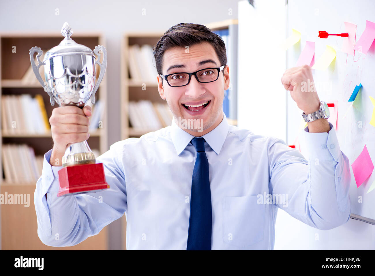 Young businessman receiving prize cup in office Stock Photo - Alamy