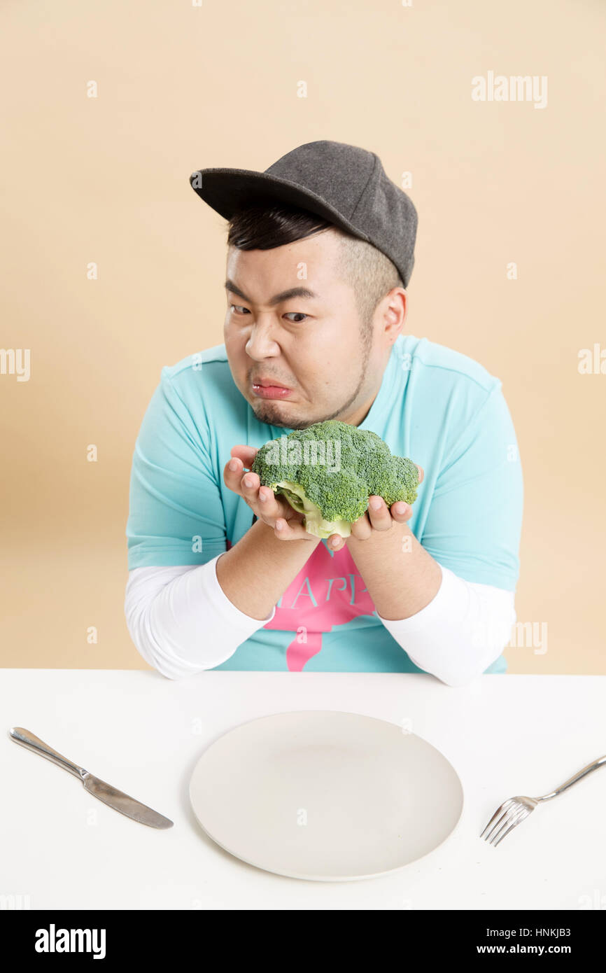 Small fat man holding broccoli Stock Photo - Alamy