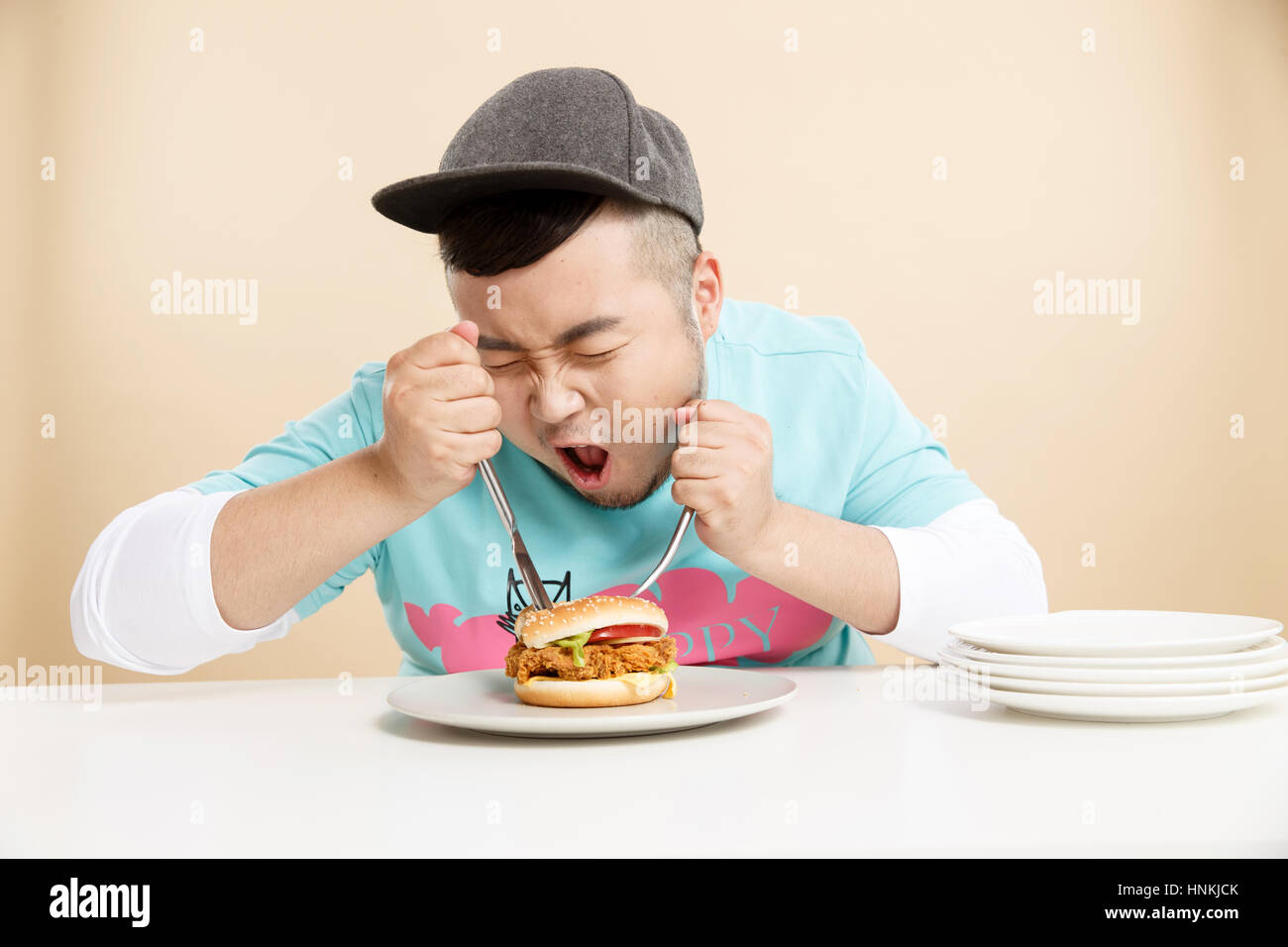 Little fat man eating hamburgers Stock Photo - Alamy
