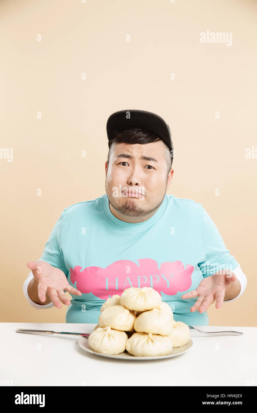 Little fat man to eat steamed stuffed bun Stock Photo - Alamy