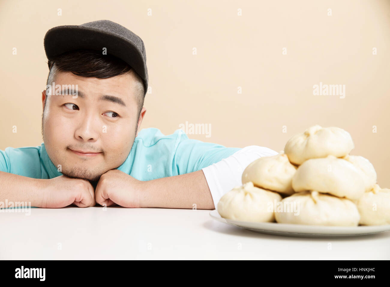 Little fat man to eat steamed stuffed bun Stock Photo - Alamy