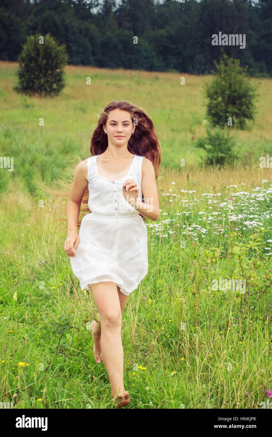 Beautiful girl with long hair running in a field Stock Photo - Alamy