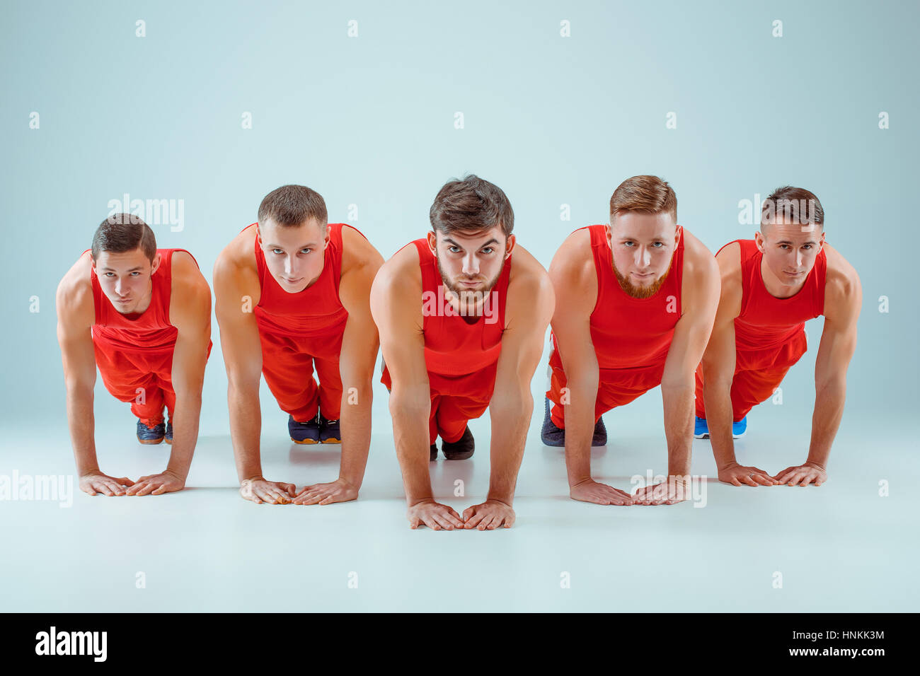 The group of gymnastic acrobatic caucasian men posing in balance ...