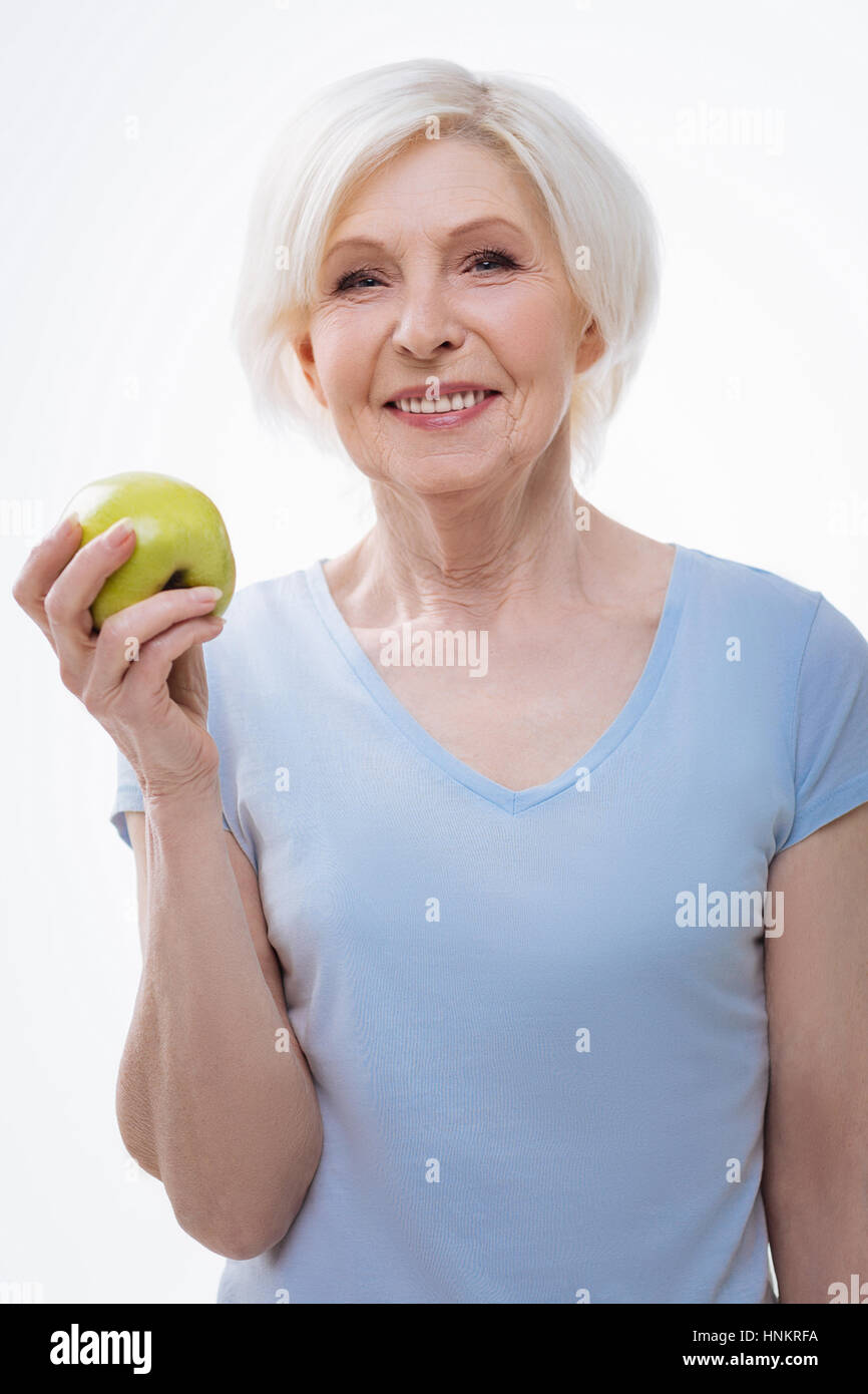 Positive delighted pretty female holding big apple Stock Photo - Alamy