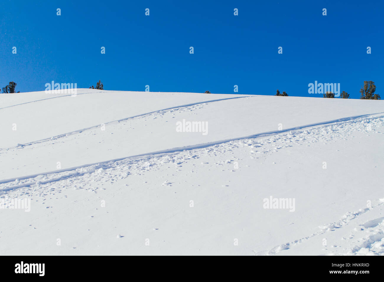 Snow slope on a blue sky background Stock Photo - Alamy