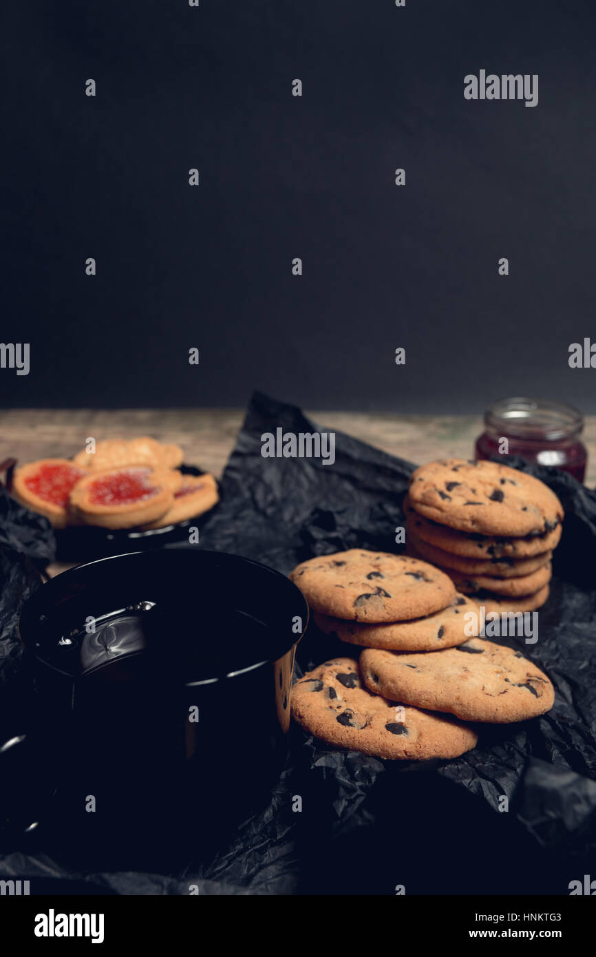 cookies and biscuits on black table background. Afternoon break time ...