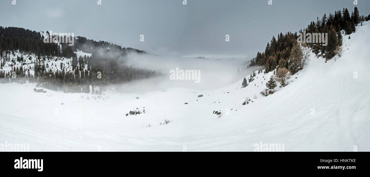 Panoramic view of a snow covered mountain range looking down valley ...