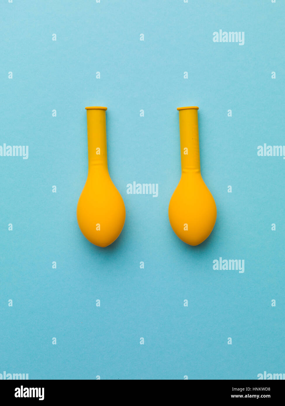 two yellow balloons on a blue background Stock Photo - Alamy