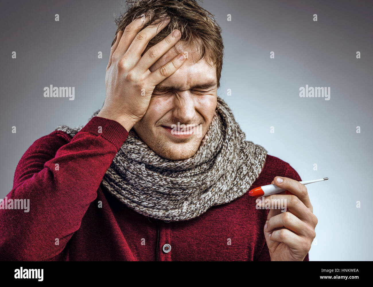 Man suffering from severe headache. Photo of sick man in scarf holding ...