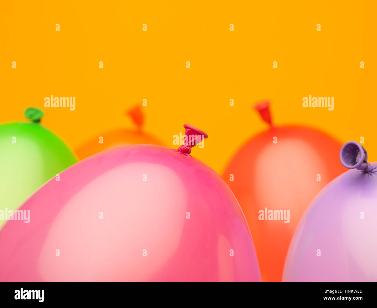 composition made of five upright balloons with tails on a yellow ...