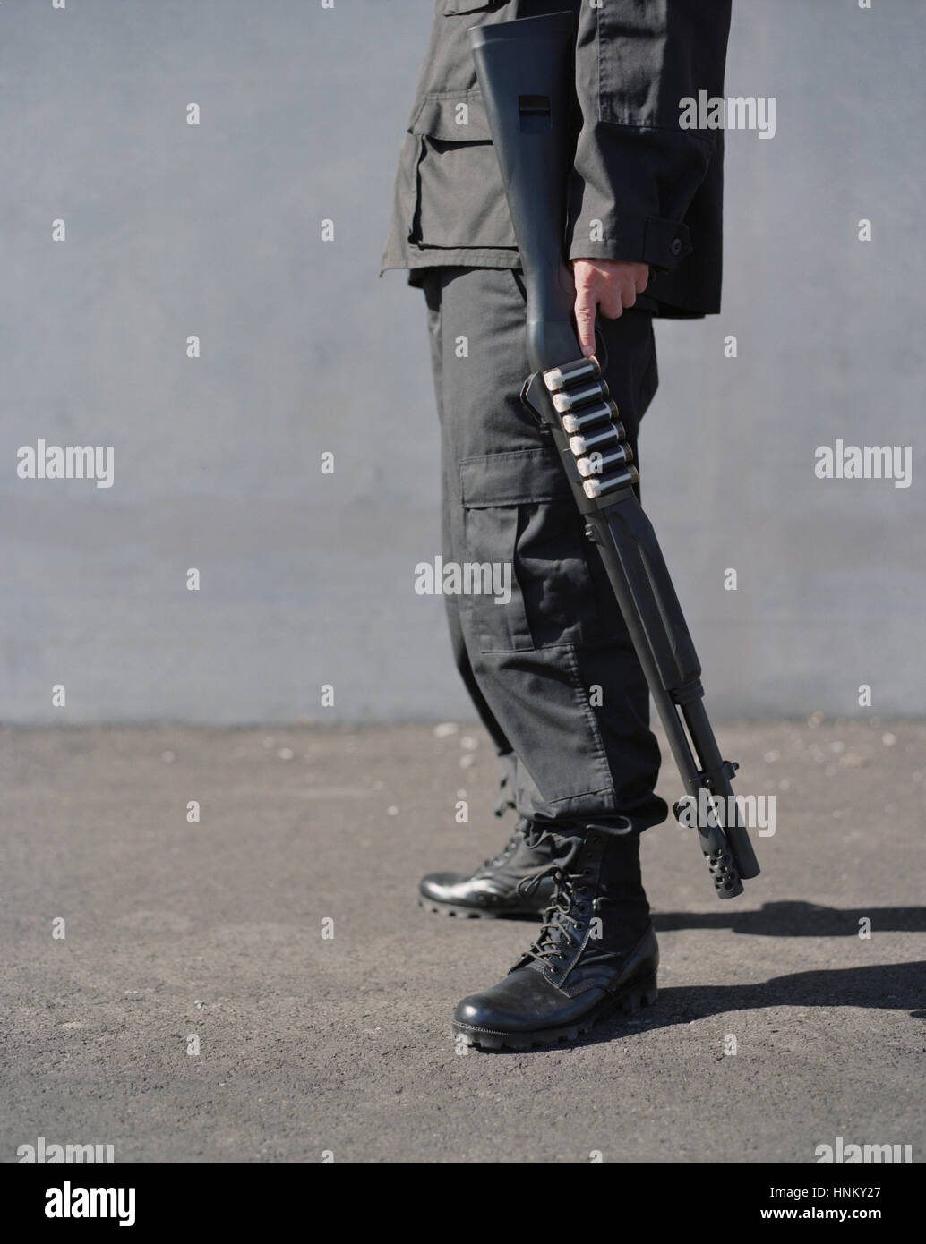 Cropped view of man in special forces, holding high powered shotgun ...