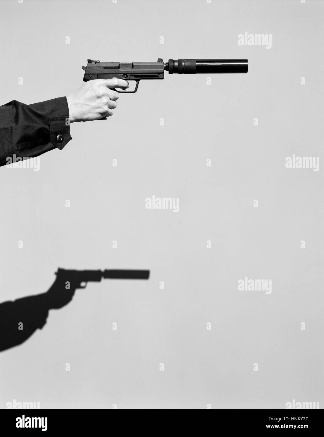 Detail of man aiming high powered hand gun with silencer Stock Photo ...