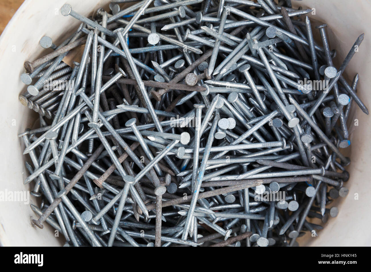 A bucket of metal pins or nails Stock Photo - Alamy