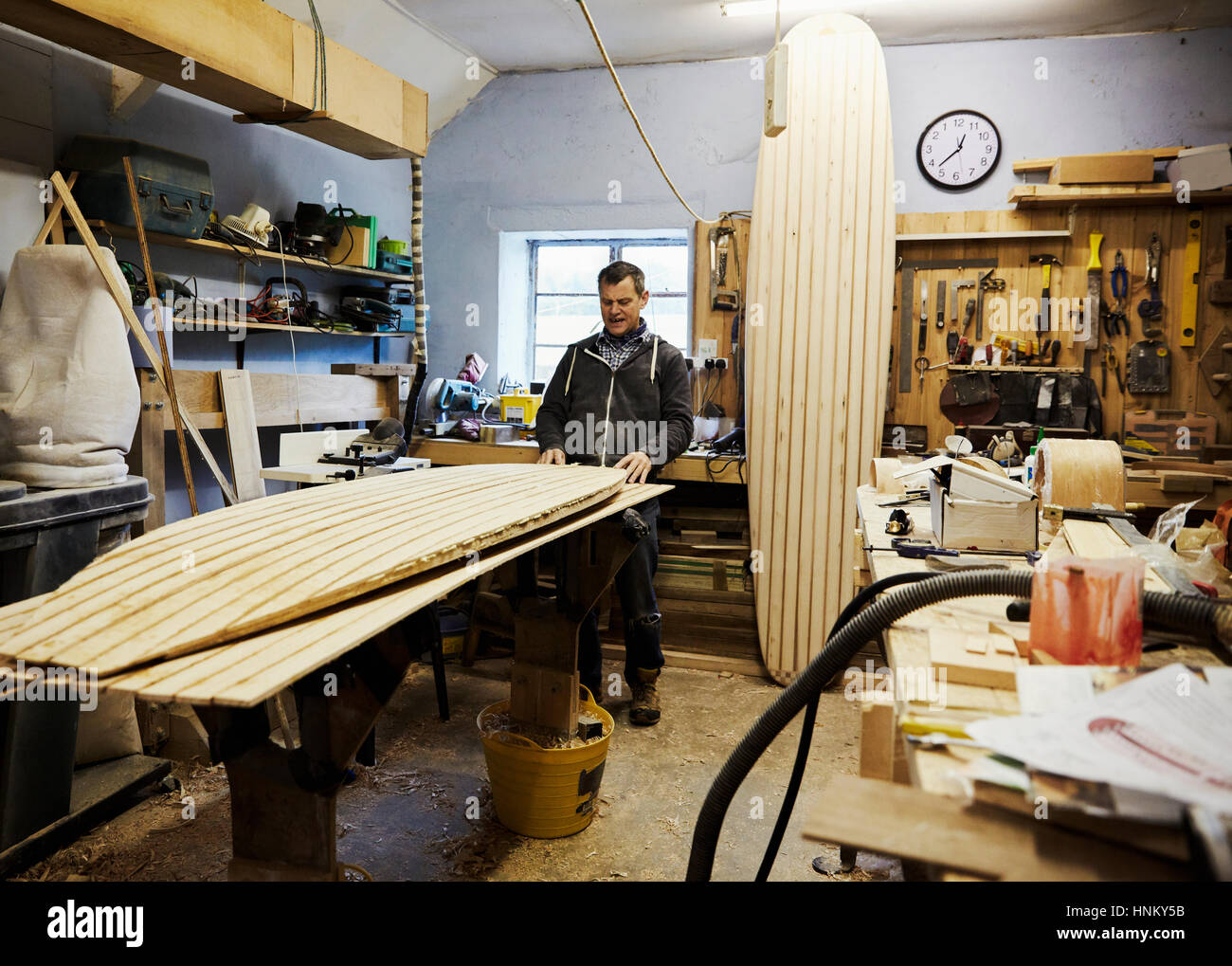 A surfboard workshop, a long board leant upright and a board in ...
