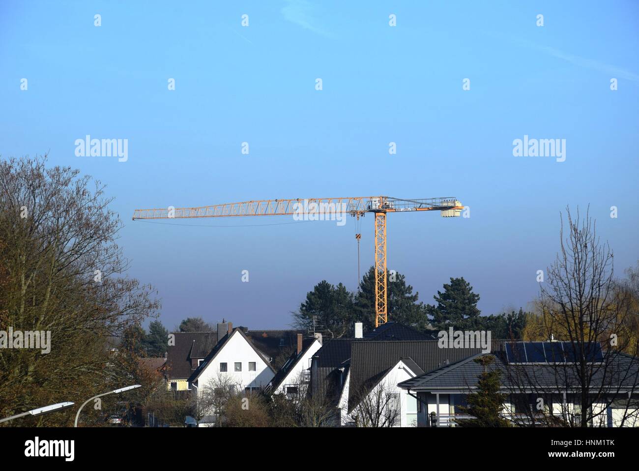 Construction crane hanging over the small houses, giving the impression ...