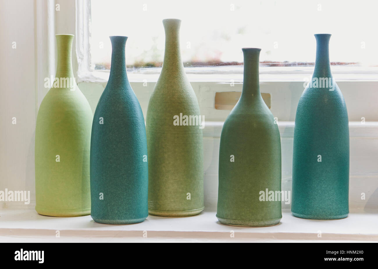 Green and Turquoise bottles on a windowsill Stock Photo - Alamy