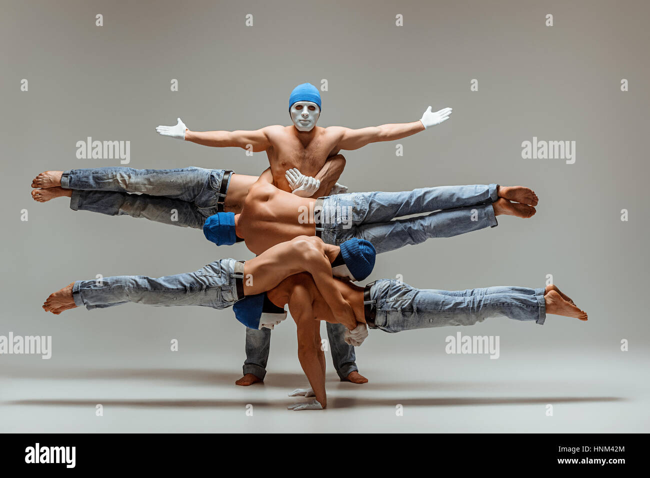 The group of gymnastic acrobatic caucasian men posing in balance ...