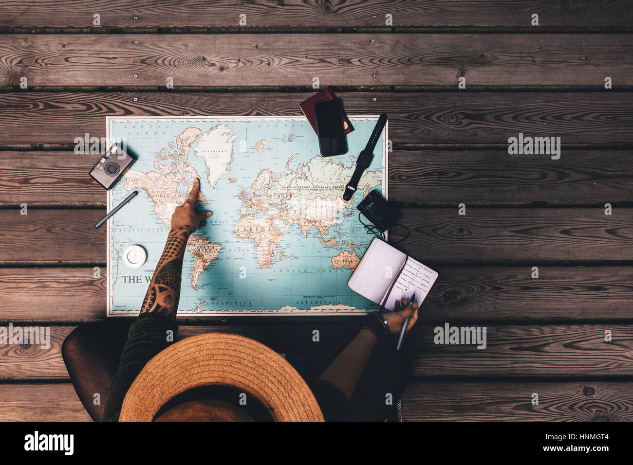 Top view of woman making her vacation plan sitting in front of world ...