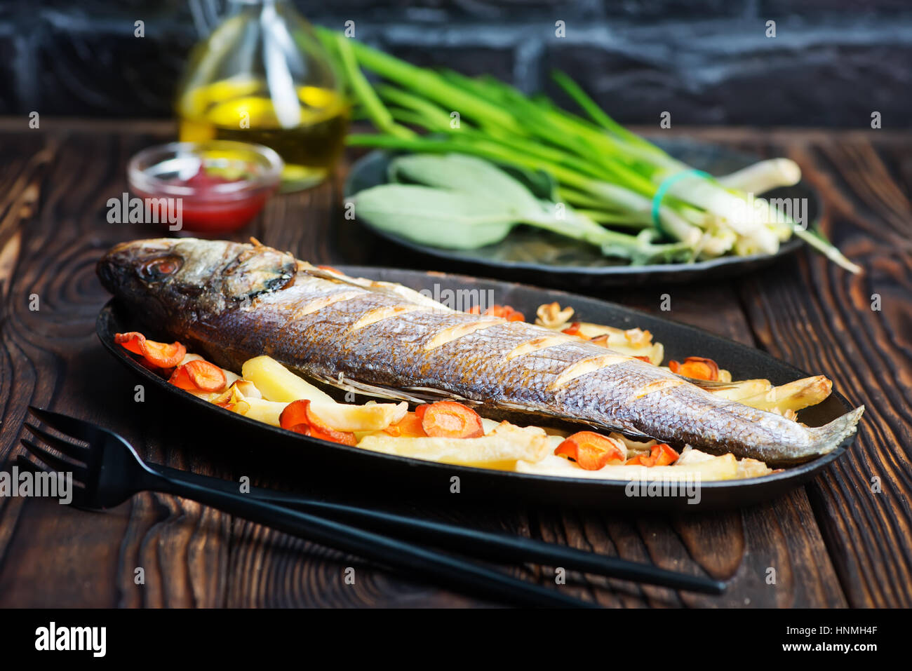 baked fish with vegetable on a table Stock Photo - Alamy