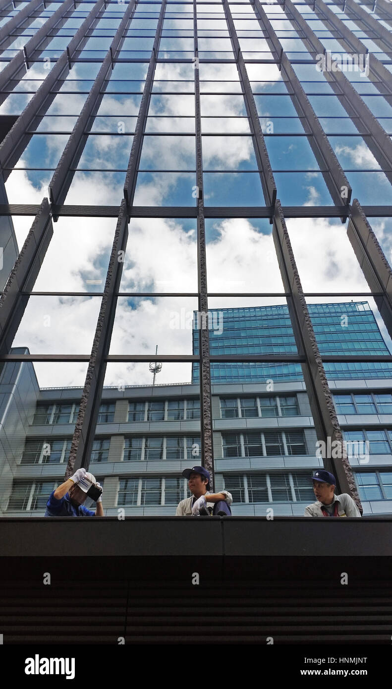 Maintenance workers at the entrance of an office building in Tokyo ...