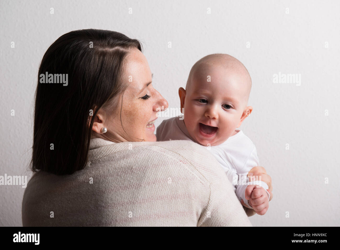 Beautiful mother holding baby son in her arms. Studio shot Stock Photo - Alamy