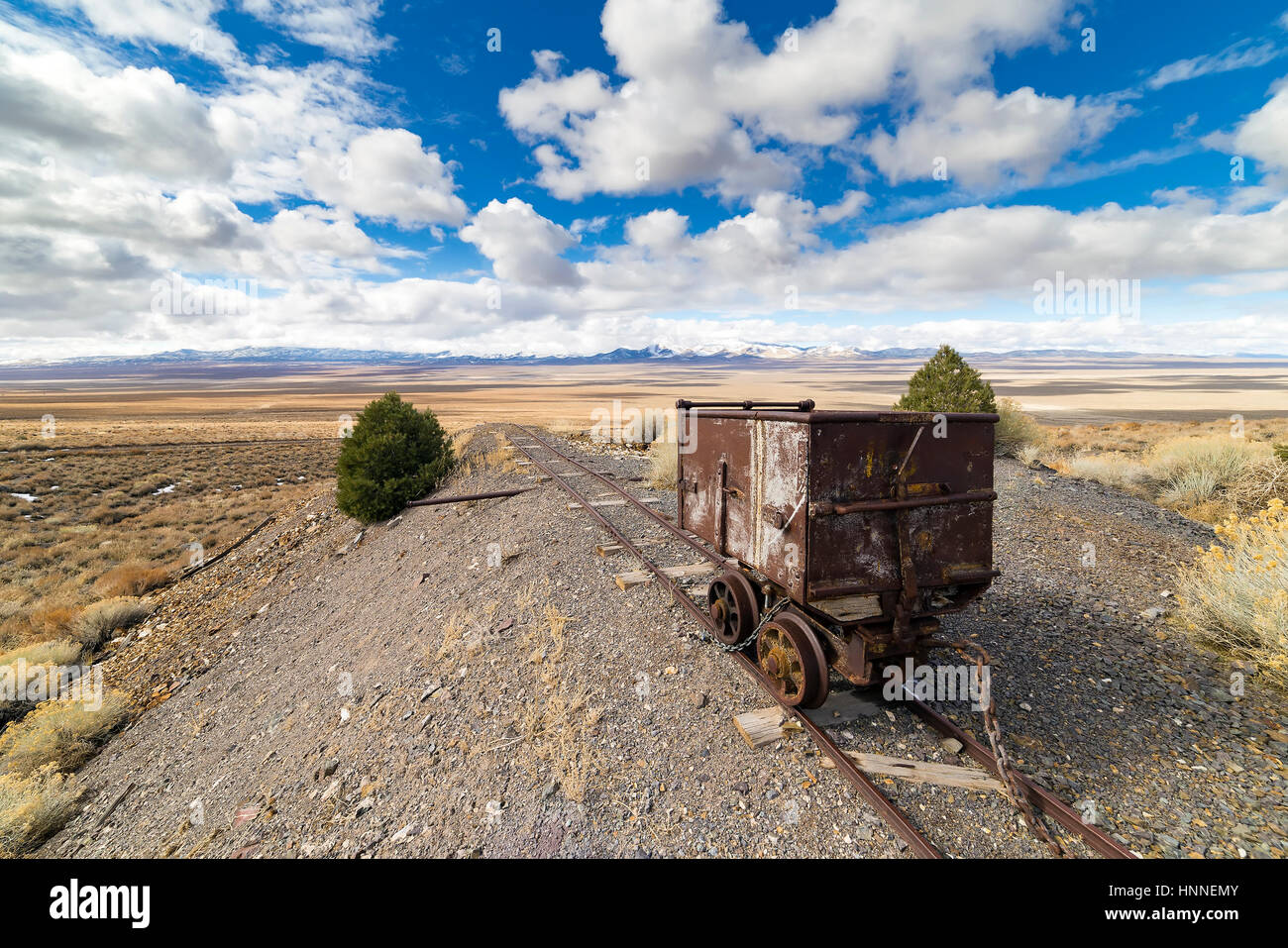 Old mining ore cart on tracks underneath a beautiful blue sky with ...