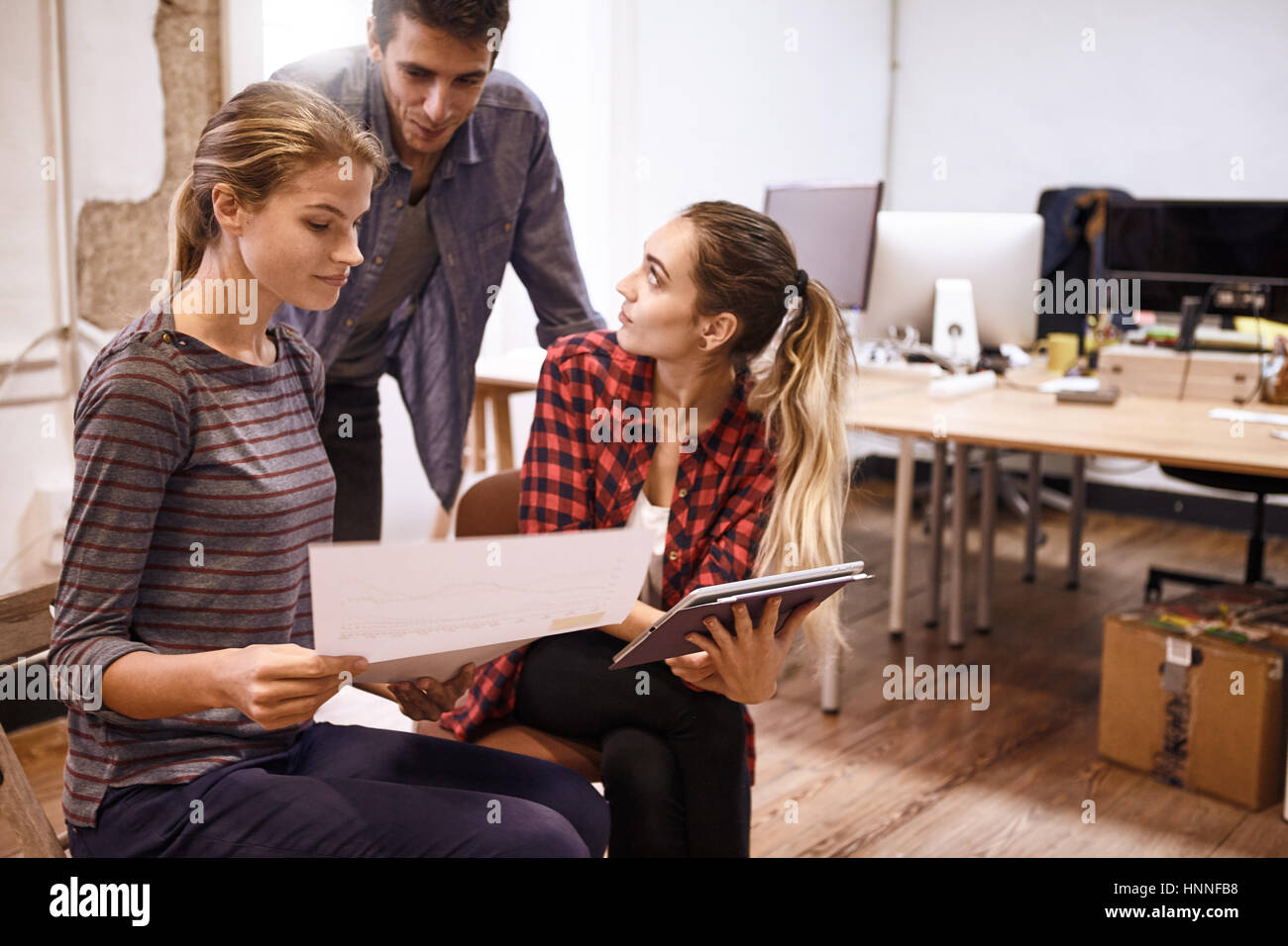 Group of three young business people in a meeting the man standing ...