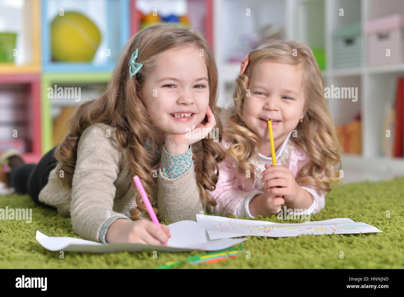 Two cute little girls drawing Stock Photo - Alamy