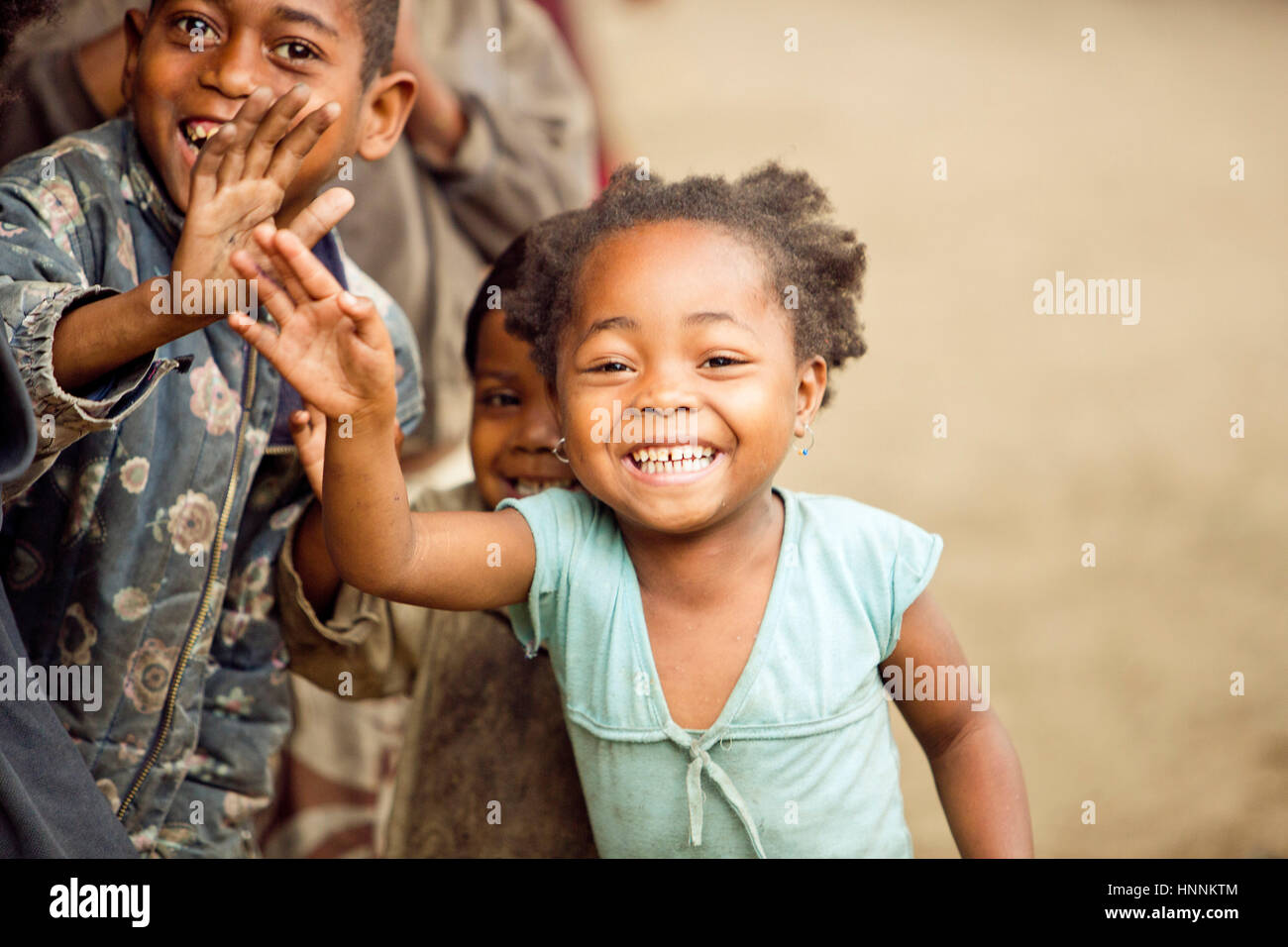 Smiling portrait of waving little children taken in rural fisherman's ...