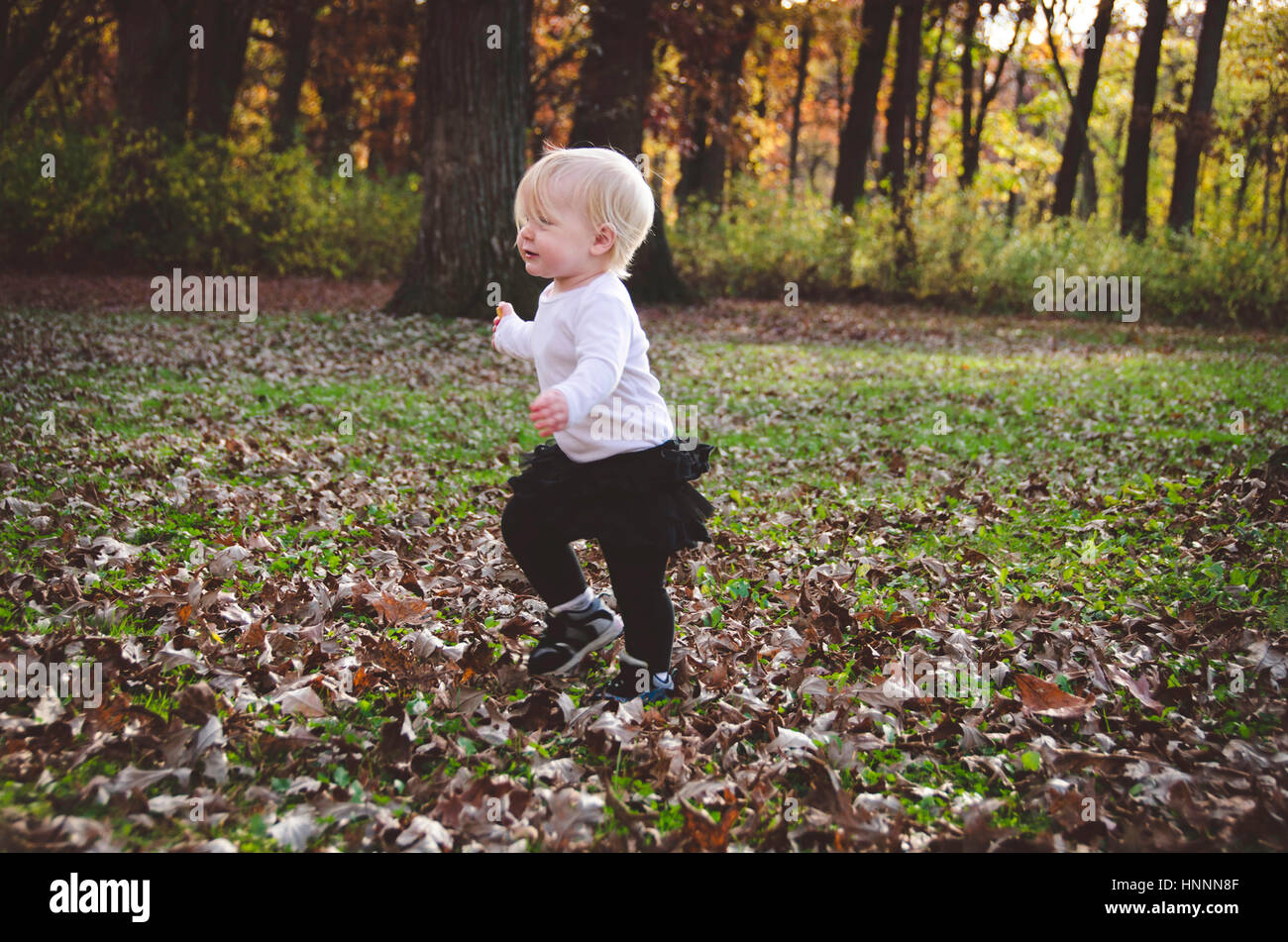 Side view of cute baby girl walking on grassy field Stock Photo - Alamy