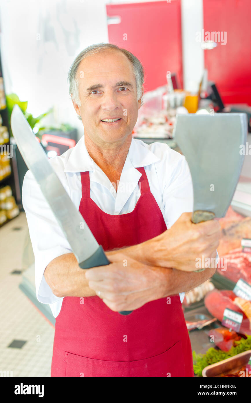 Butcher with machete in one hand and long bladed knife in the other ...