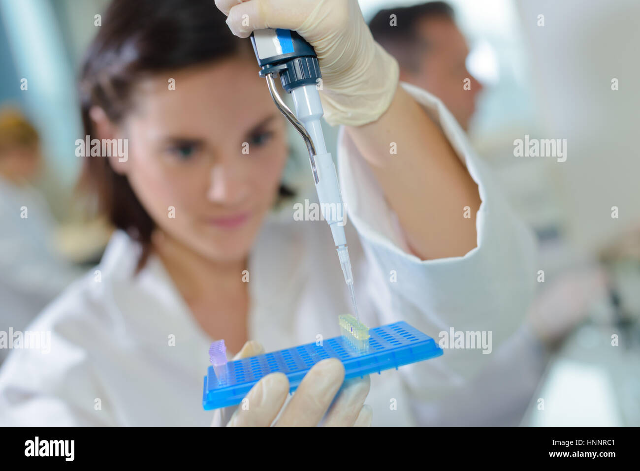 Woman taking samples from pipette Stock Photo - Alamy