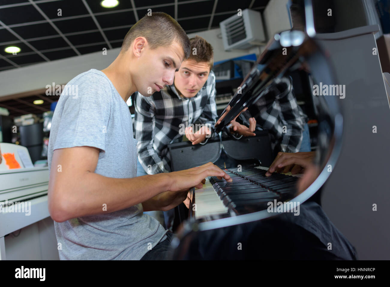 Young man playing piano hi-res stock photography and images - Alamy