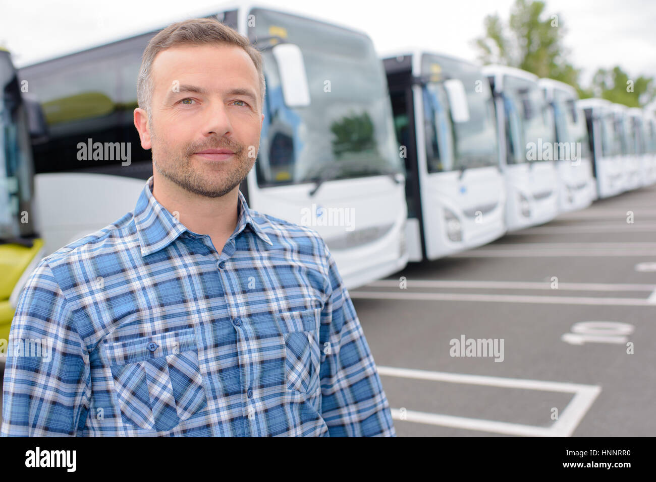 man posing in a row of coaches Stock Photo - Alamy
