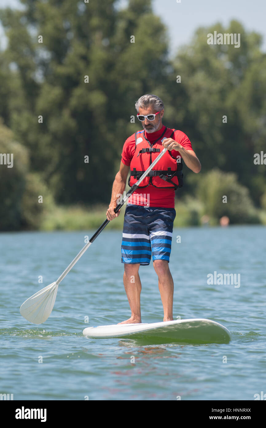 man enjoying a ride on the lake with paddleboard Stock Photo - Alamy