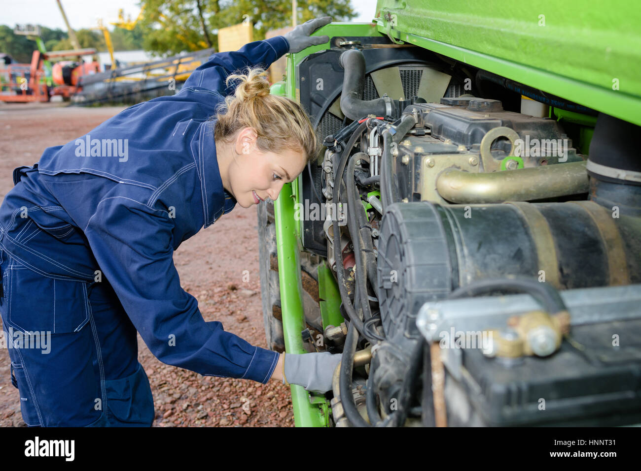 Woman working on engine of plant machinery Stock Photo - Alamy