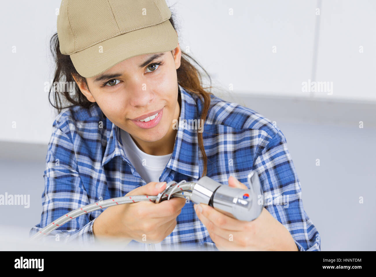 female plumber fixing kitchen sink tap Stock Photo - Alamy