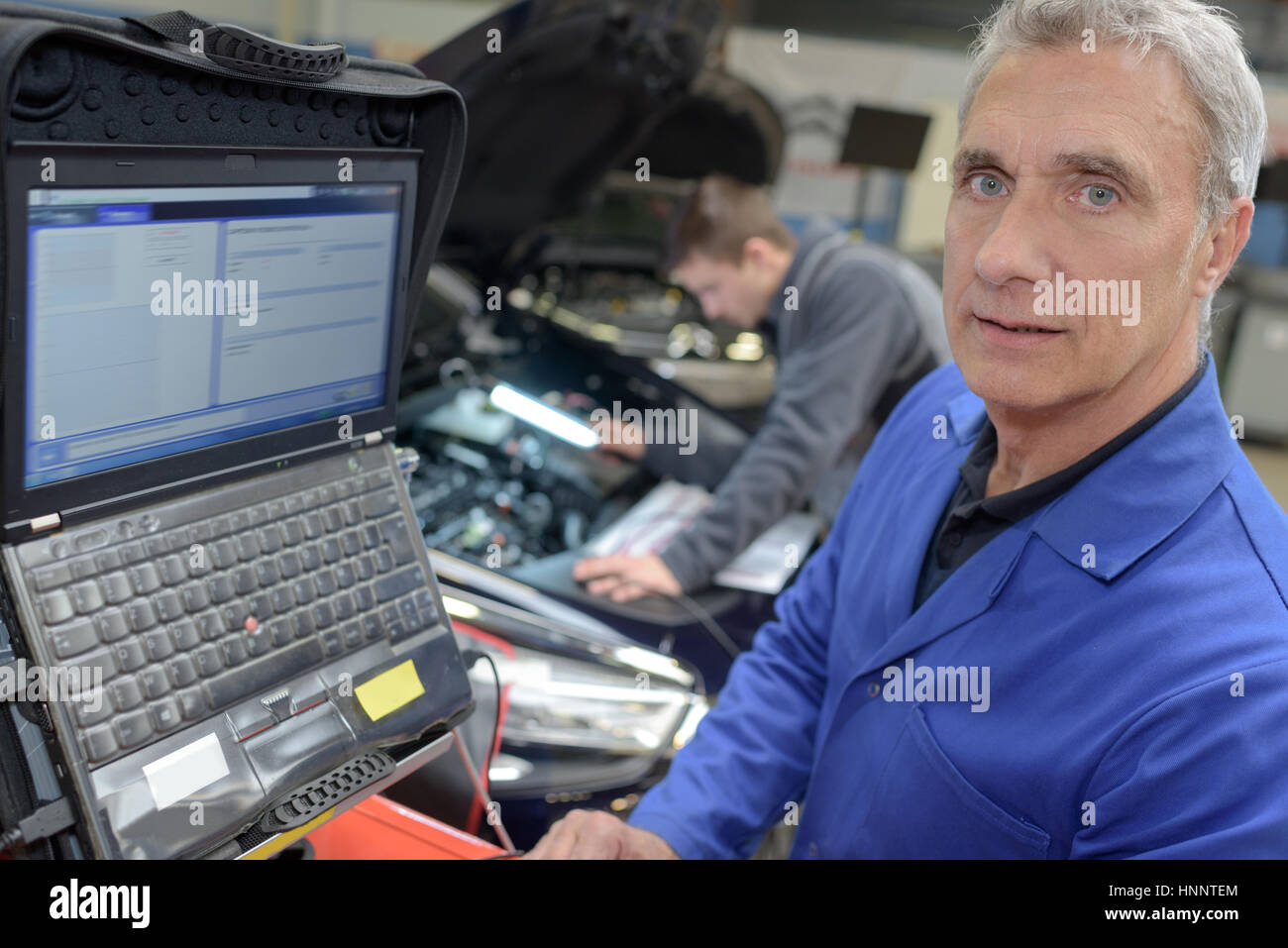 auto mechanic teacher and trainee performing tests at mechanic school ...