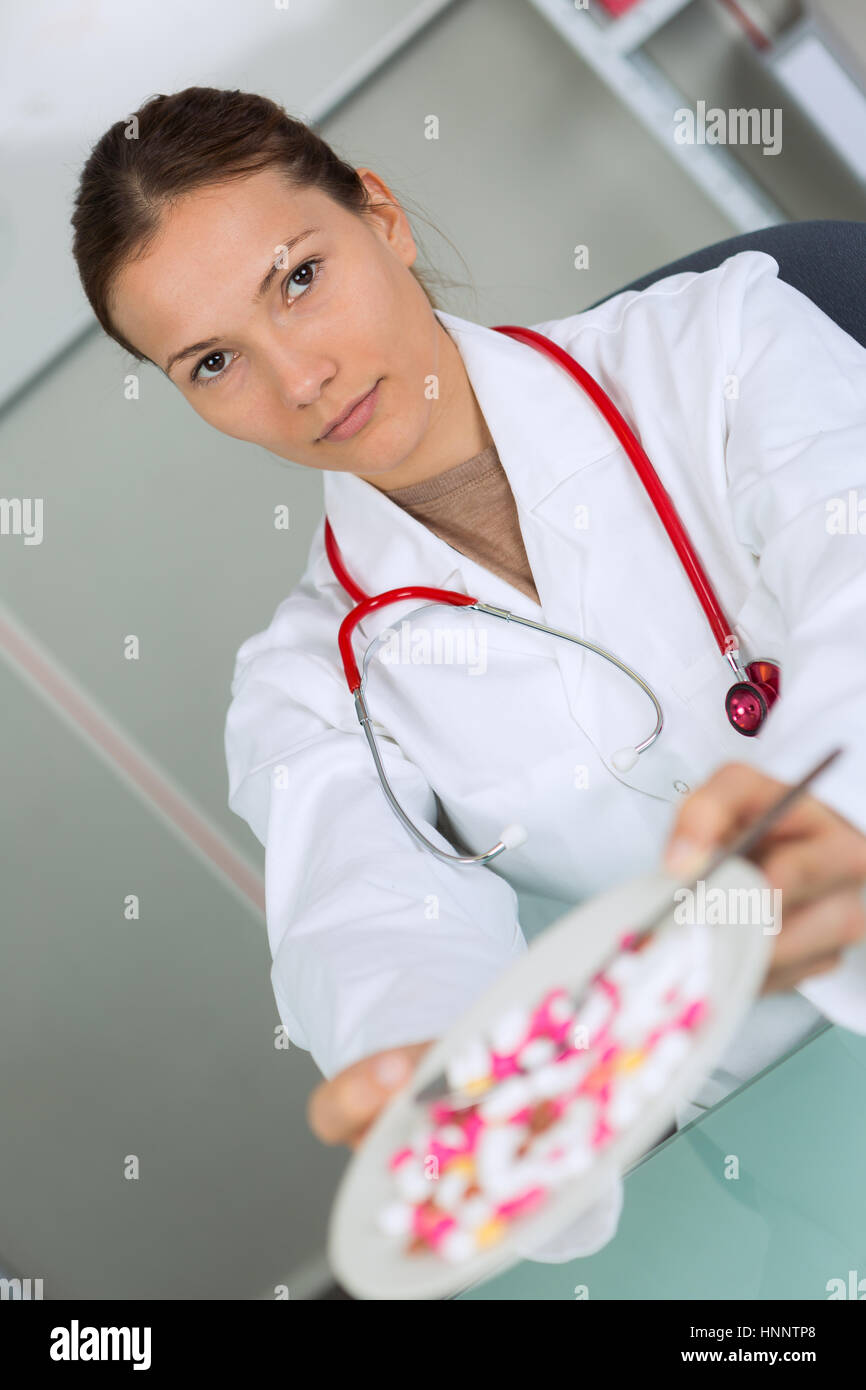 smiling doctor holding medicine in her office Stock Photo - Alamy