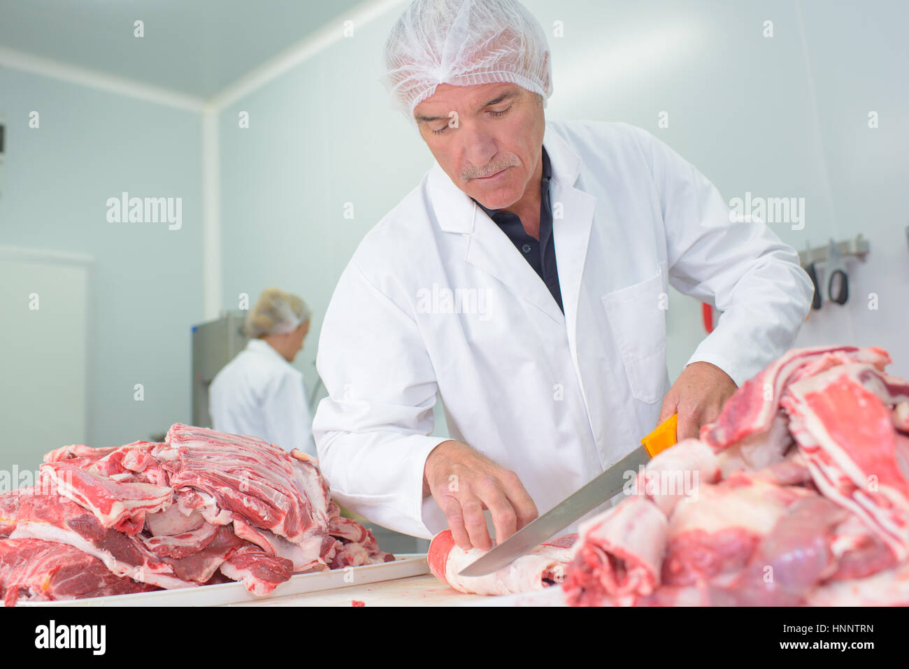 Butcher preparing cuts of meat Stock Photo - Alamy