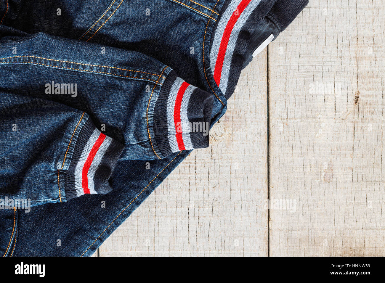 jackets of jeans on a wooden floor Stock Photo - Alamy